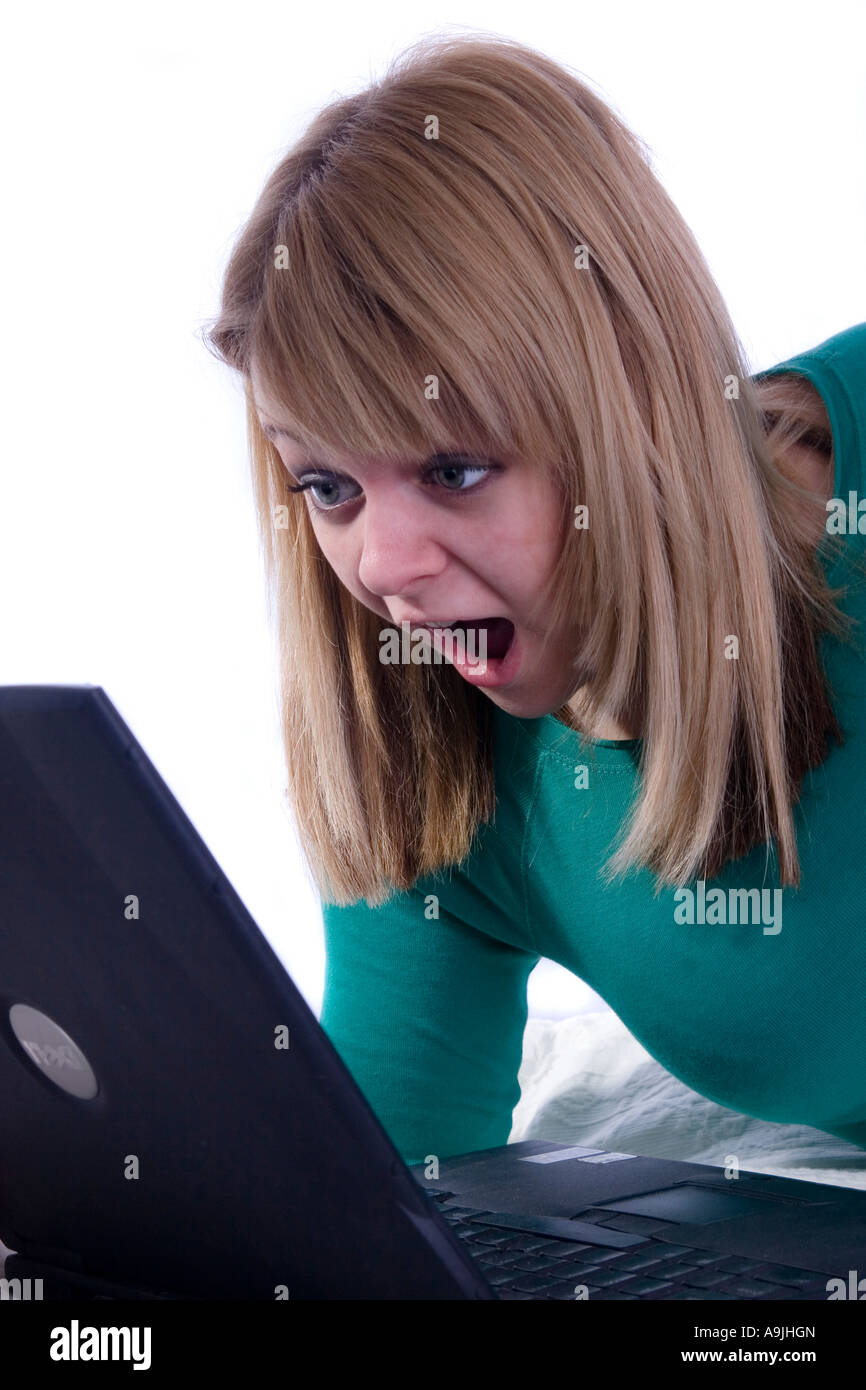 young girl using laptop computer shocked at something she has seen ...