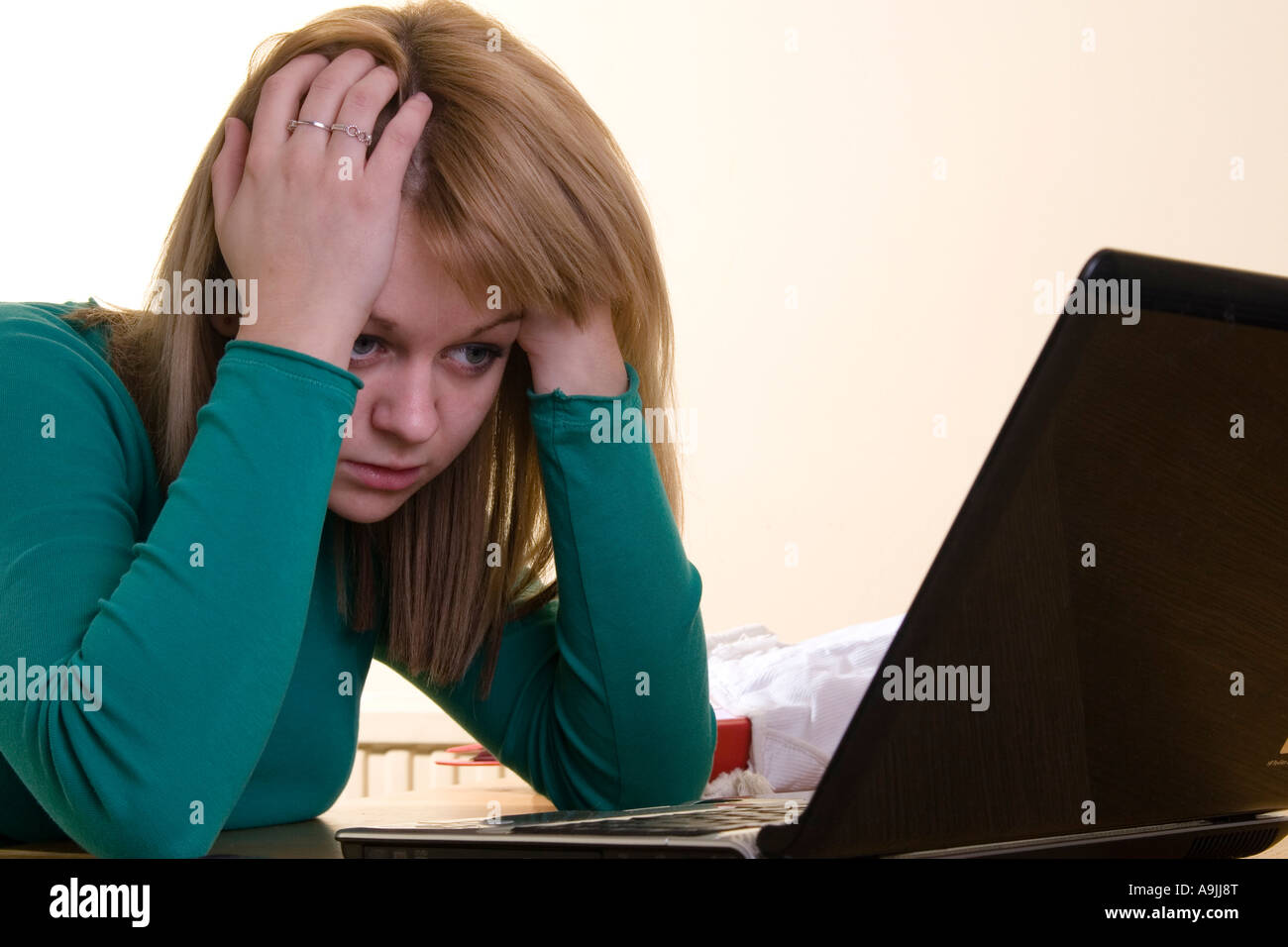 Concerned or confused young teenage girl using laptop computer Stock ...