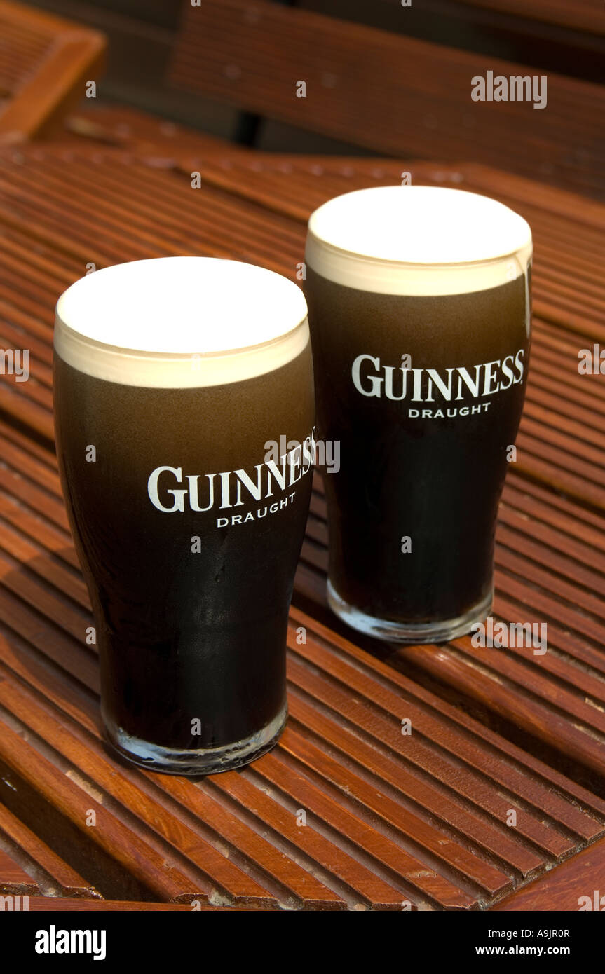 Two foaming pints of Guinness beer Stock Photo - Alamy