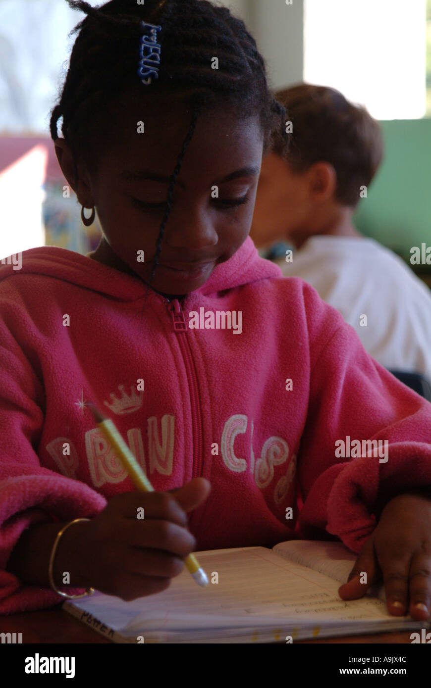 Schoolgirl writing in classroom Stock Photo - Alamy