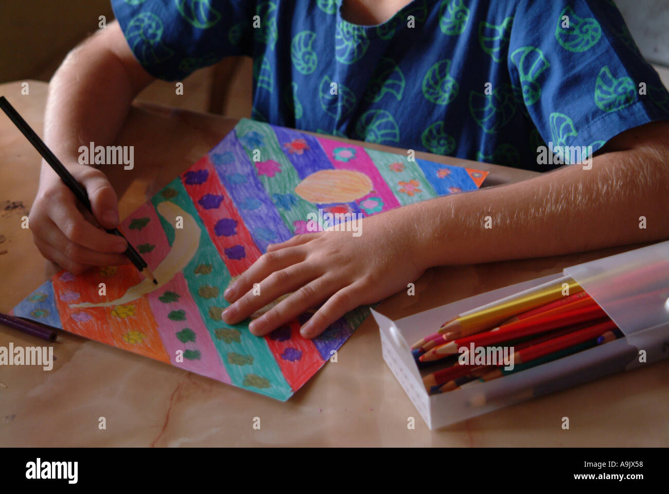 Close up of a childs hands using crayons to colour in Stock Photo - Alamy