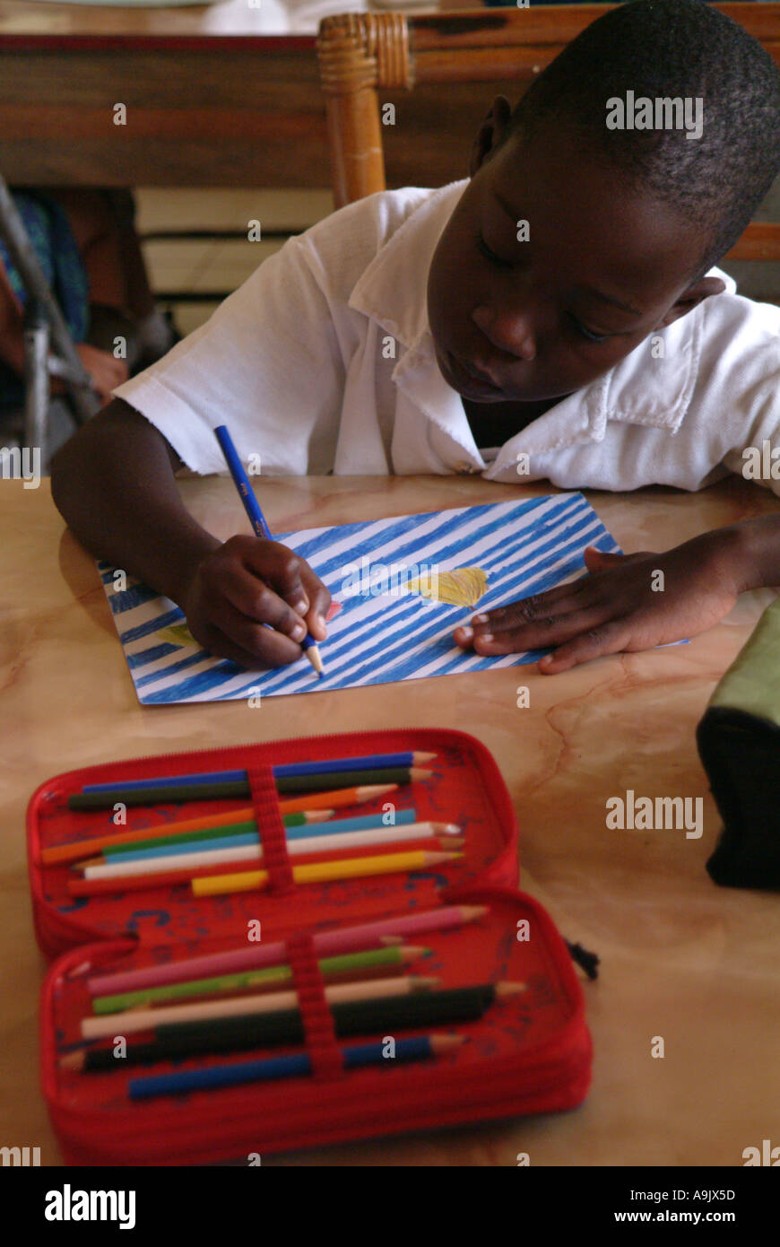 Young boy colouring in with crayons Stock Photo - Alamy