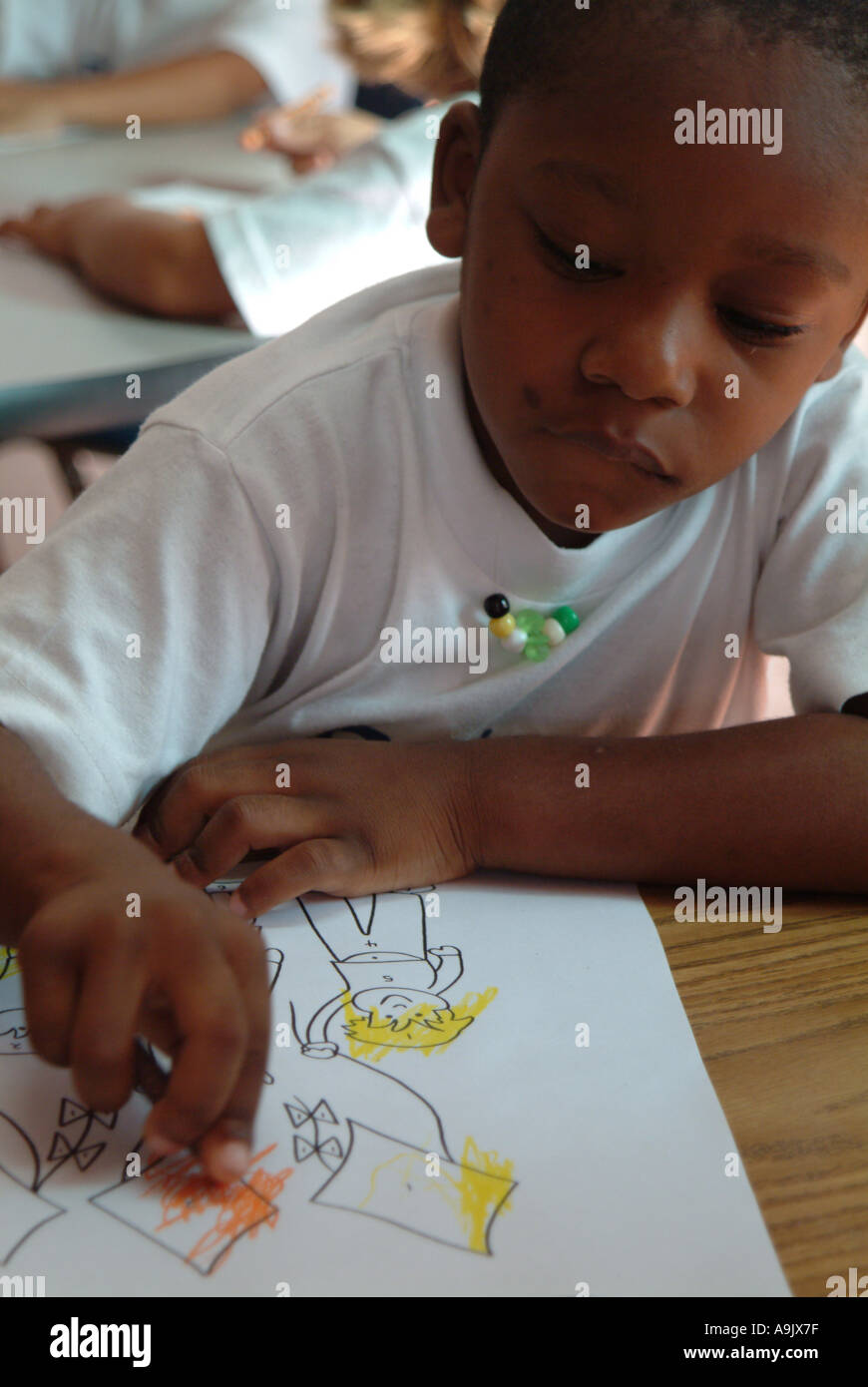Young boy colouring in with crayons Stock Photo - Alamy