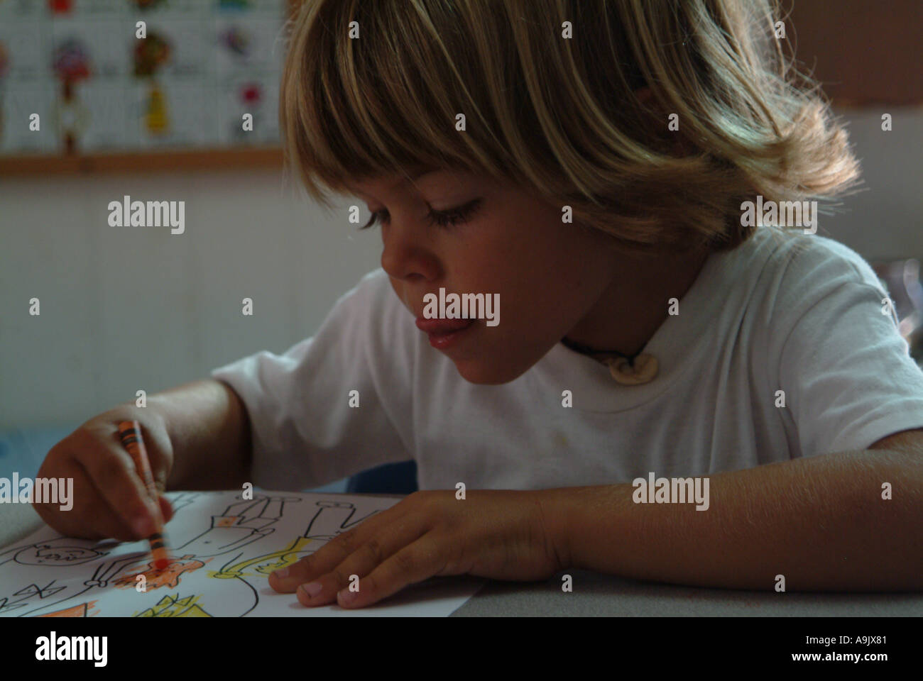 Young boy colouring in with crayons Stock Photo - Alamy