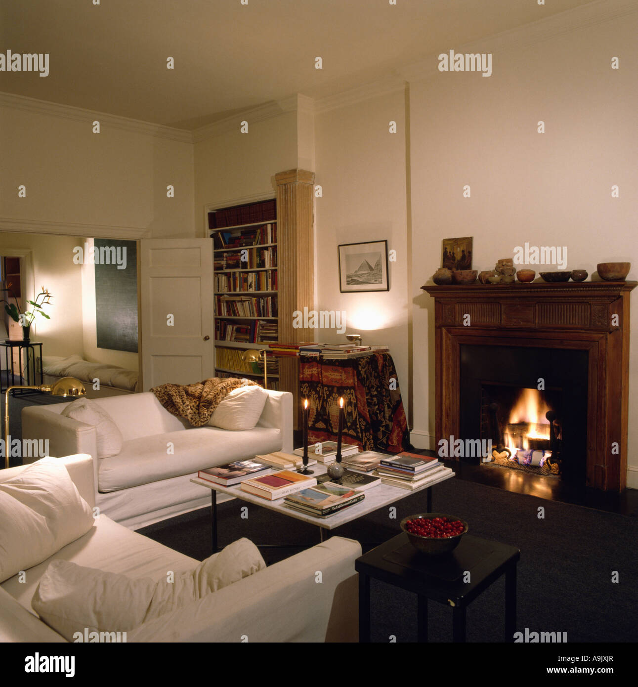 White sofas in city livingroom with fireplace with lighted fire Stock ...