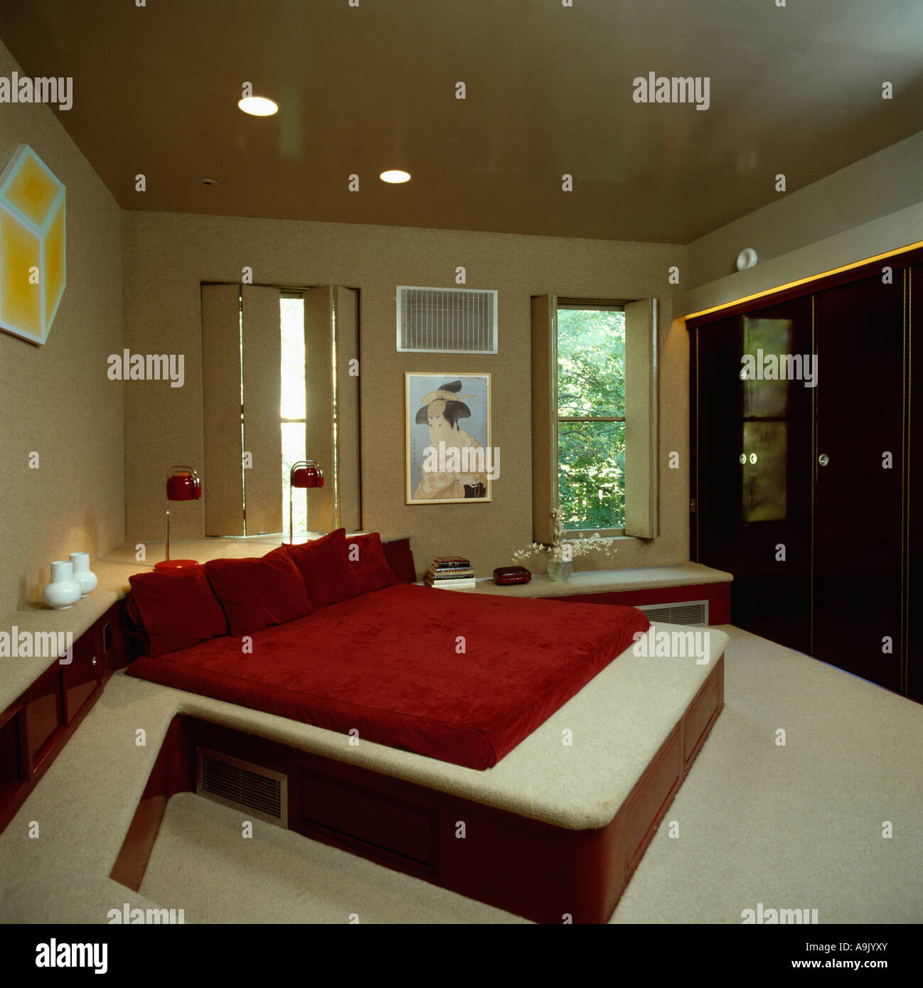 Carpeted platform with red integral bed in eighties bedroom Stock Photo ...