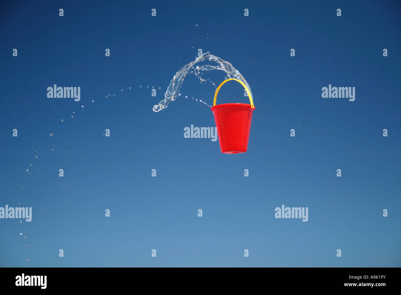 red bucket with water splashing out Stock Photo - Alamy