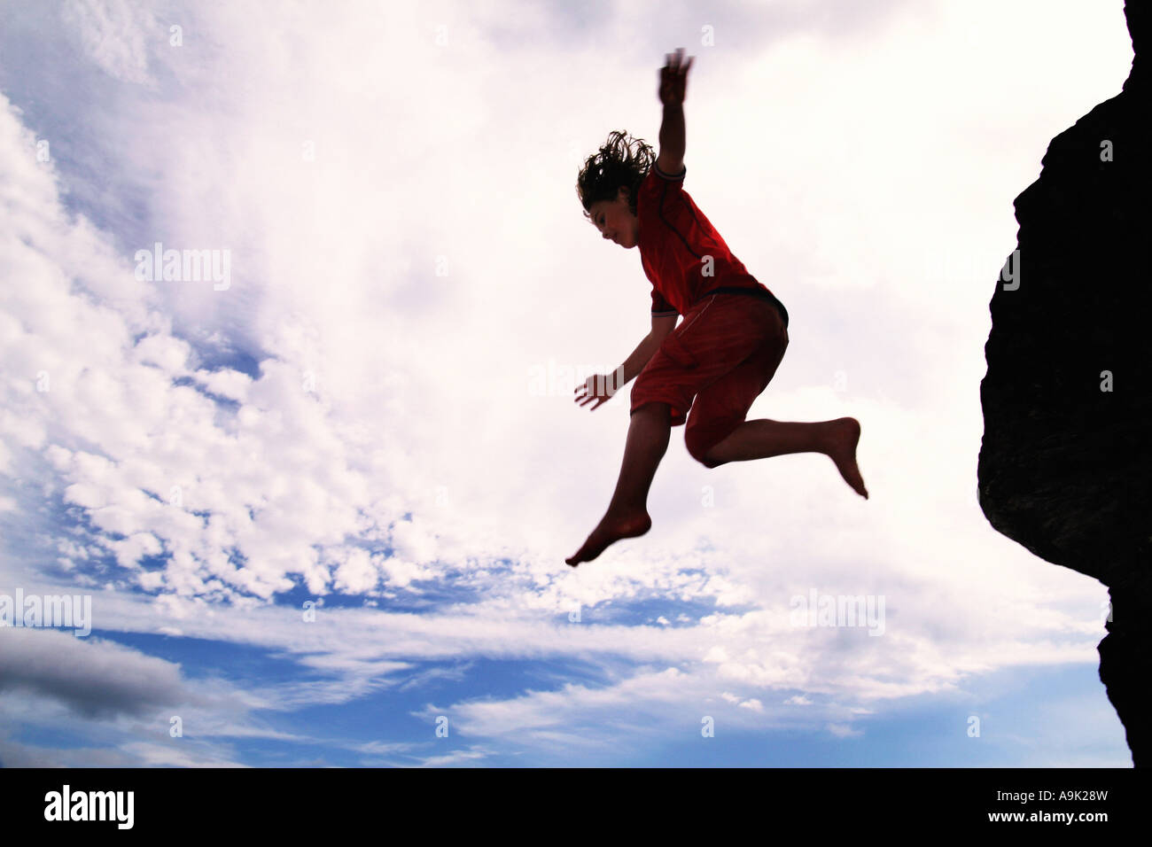 boy jumping off a rock Stock Photo - Alamy