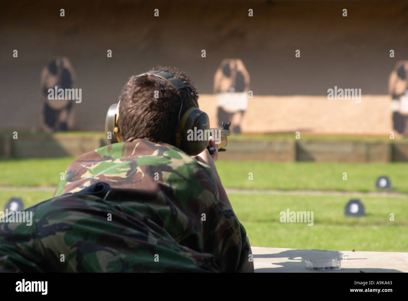 Cadet target shooting with a rifle on a 22 range Marksmen in focus ...