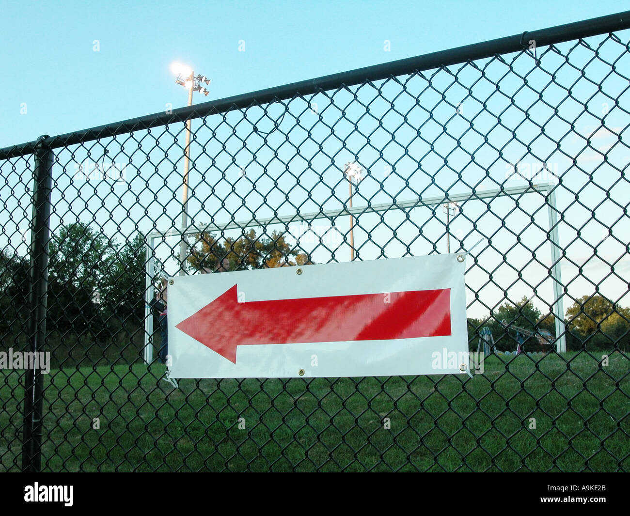 Red arrow sign on a fence by soccer field Stock Photo - Alamy