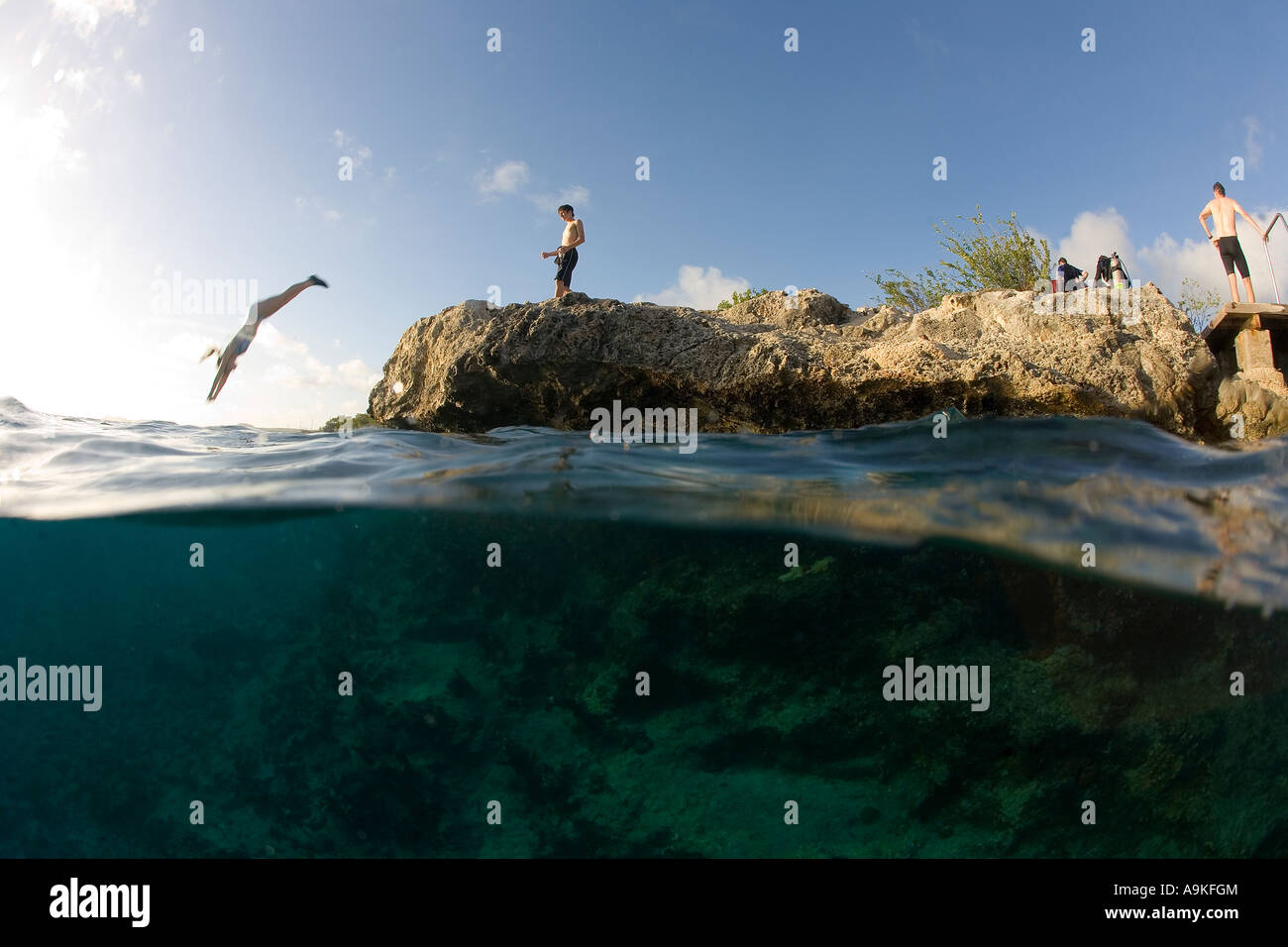 children jump into the ocean on Bonaire Island, Netherlands Antilles ...