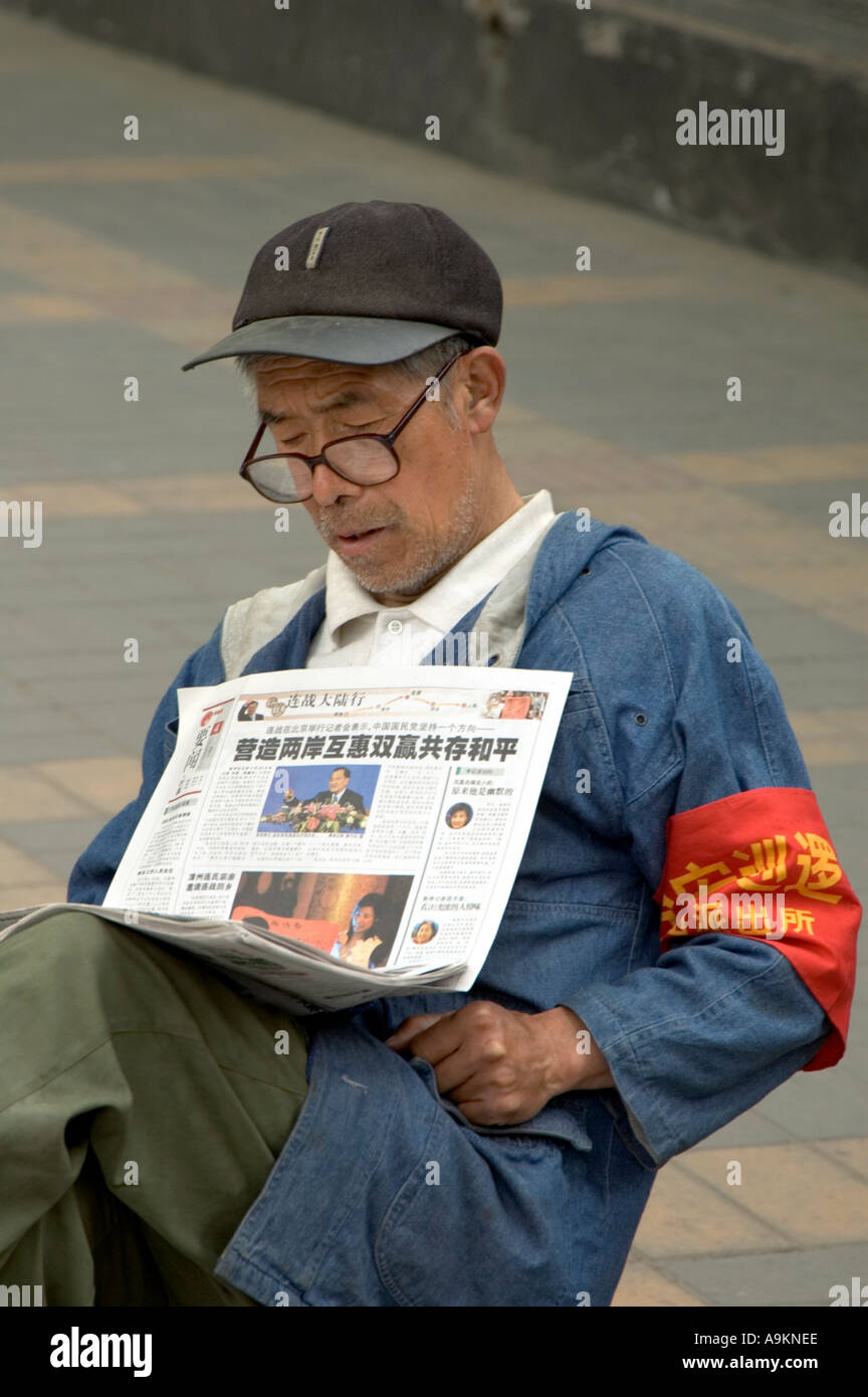 NEWSPAPER VENDOR READING DAILY PAPER IN THE STREET DONGCHENG BEIJING ...