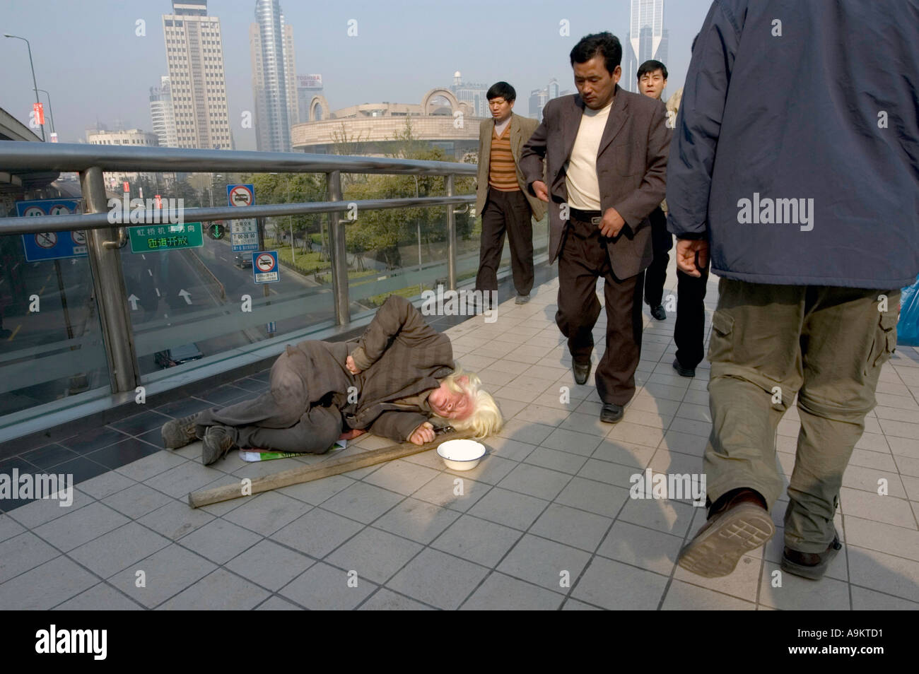 PEOPLE WALKING PAST HOMELESS PERSON PEOPLE S SQUARE SHANGHAI CHINA ...