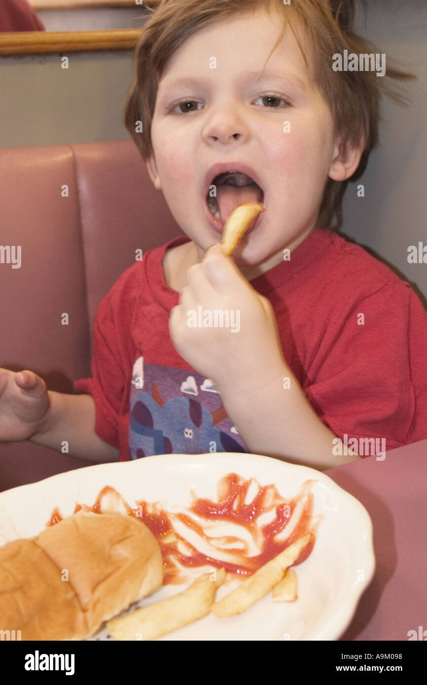 Boy age three eating fast food Stock Photo - Alamy