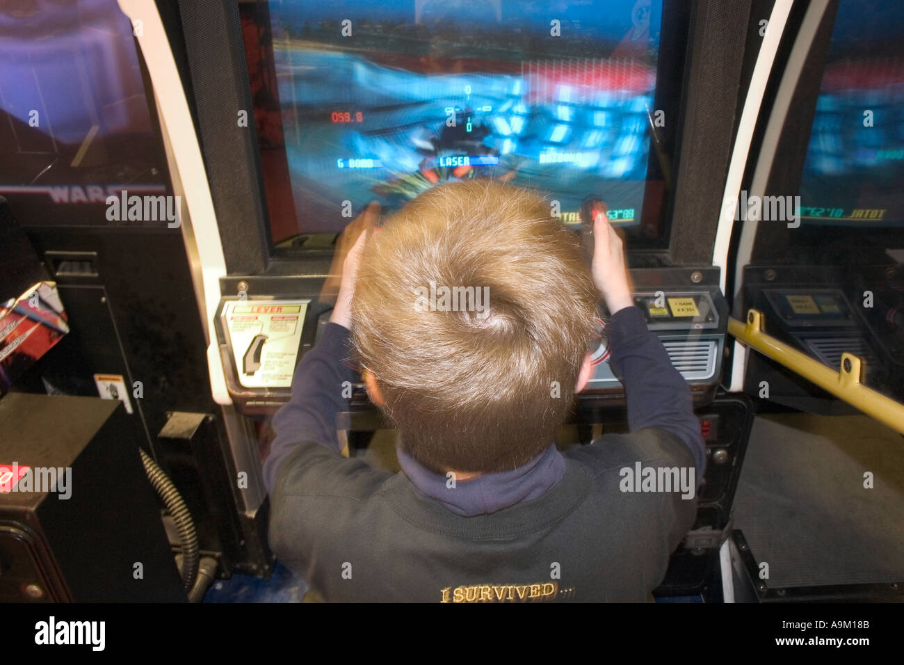 Boy playing video game in arcade Stock Photo - Alamy
