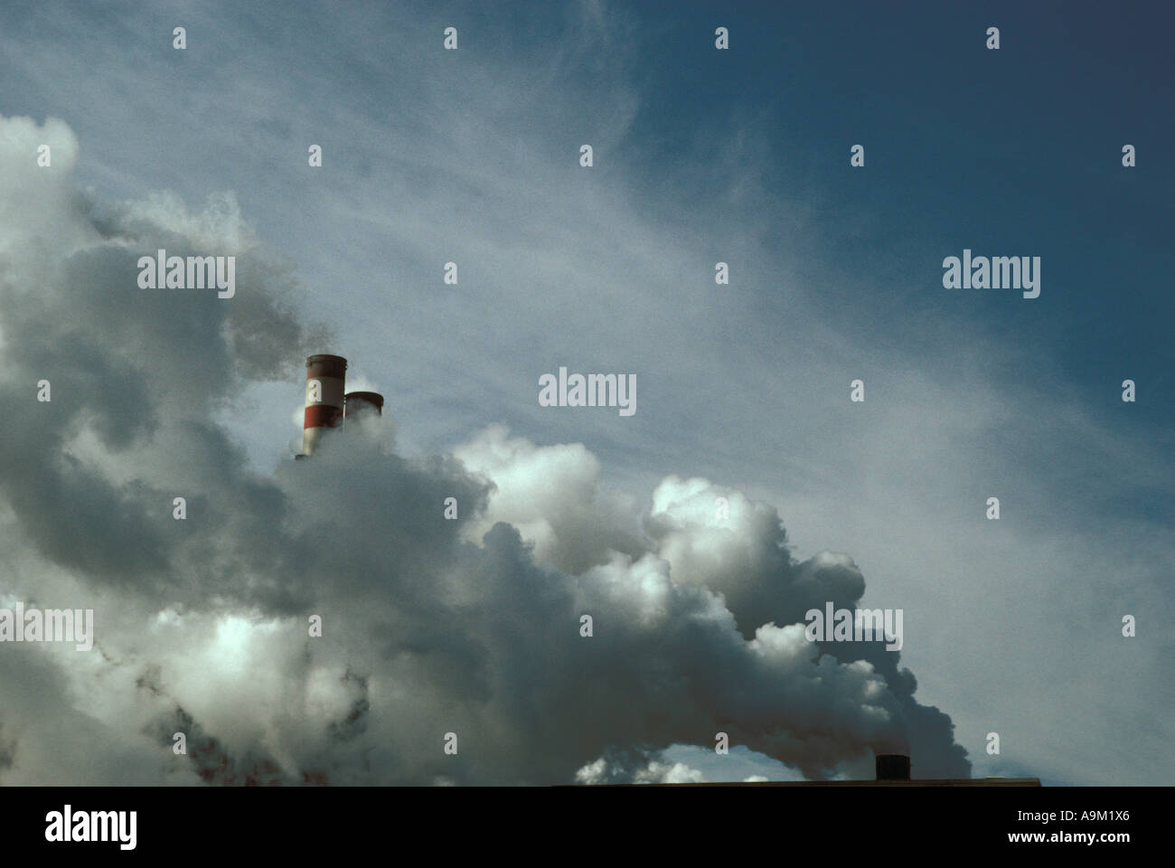 large factory billowing smoke stack smokestacks against blue sky cloud ...