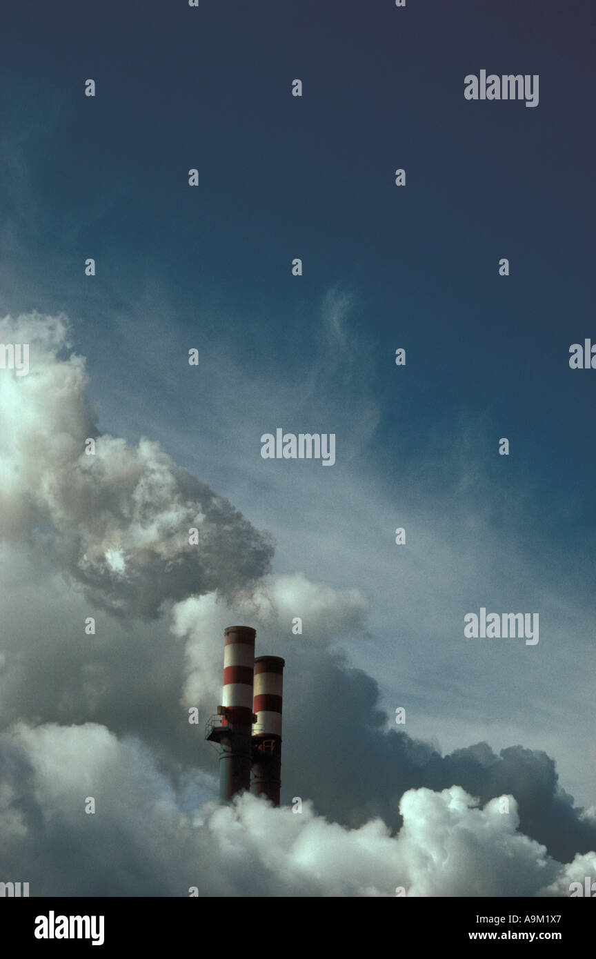 large factory billowing smoke stack smokestacks against blue sky cloud ...