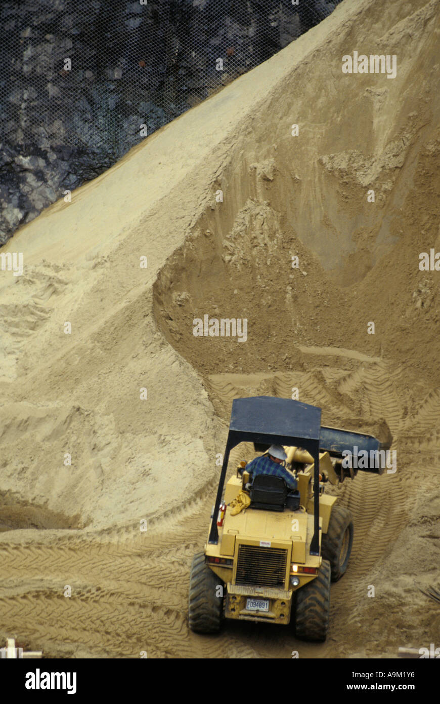 backhoe tractor moves sand gravel around large construction pit Stock ...