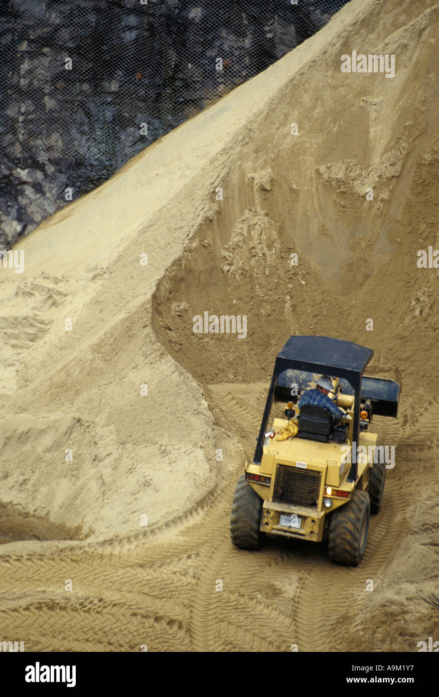 backhoe tractor moves sand gravel around large construction pit Stock ...