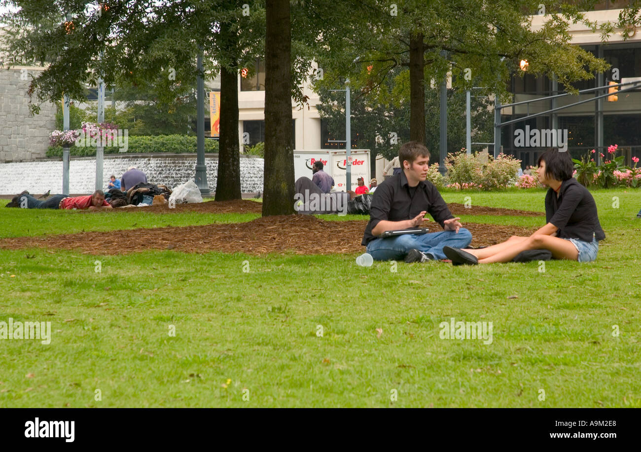 Male and Female Student (age 18 - 20) talking while relaxing in Park at ...