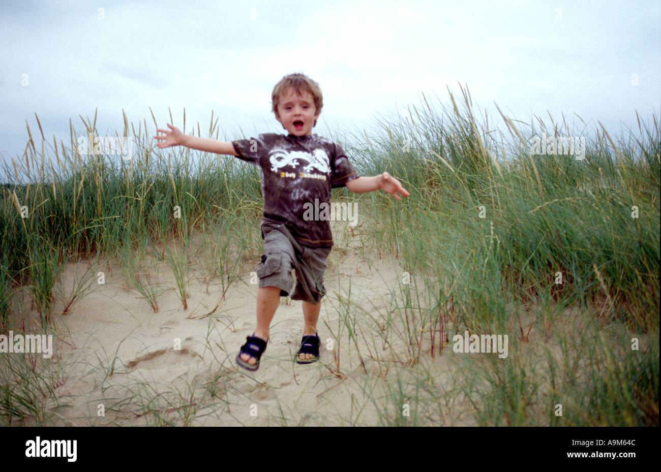 Boy running down the beach hi-res stock photography and images - Alamy