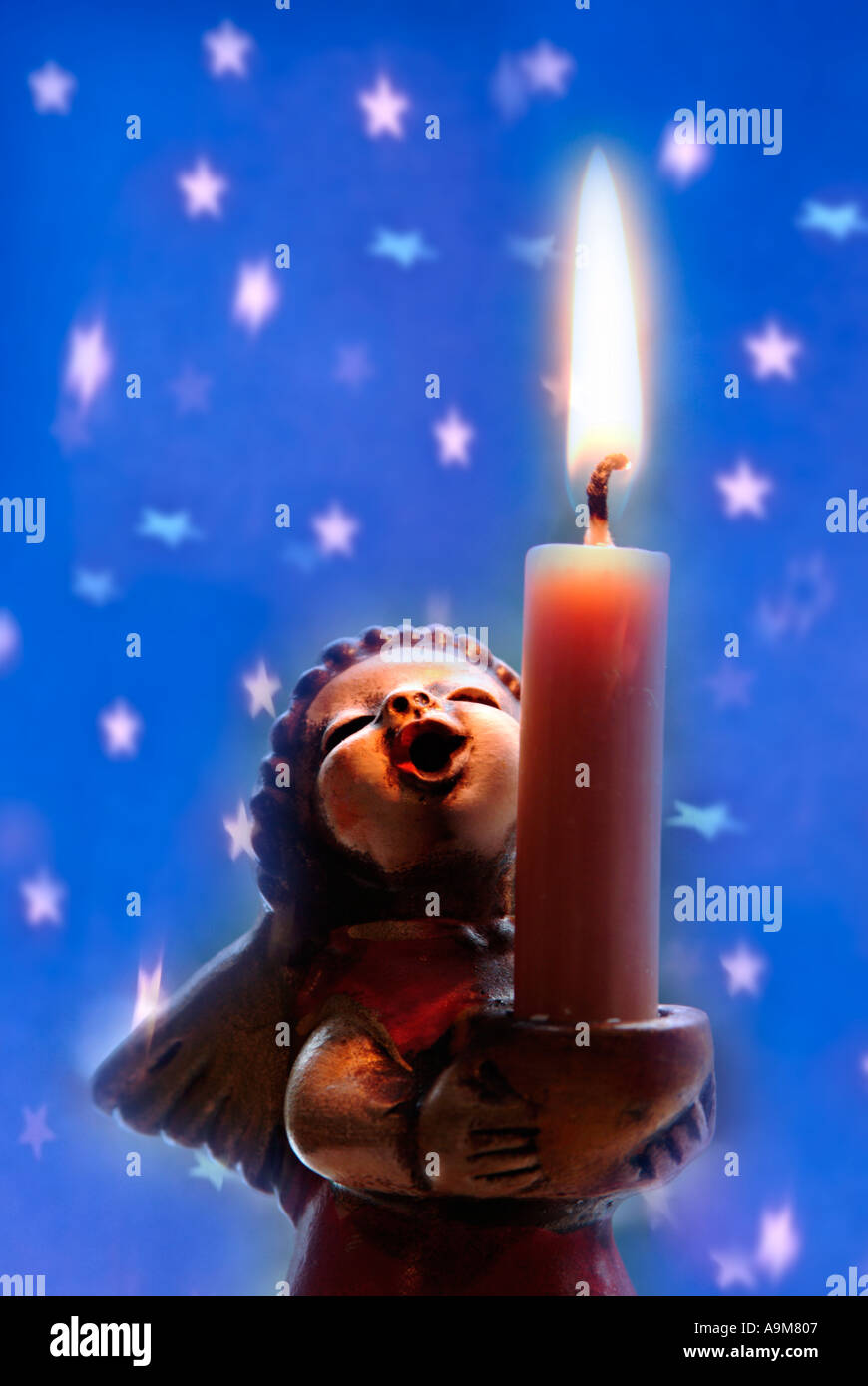 angel figure with burning candle in front of starry sky Stock Photo - Alamy