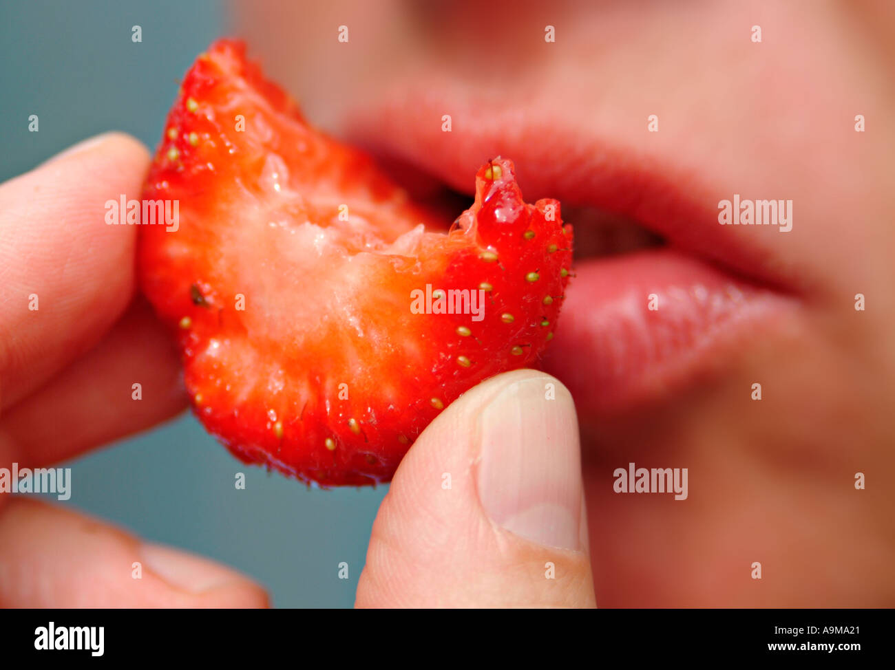 biting a strawberry Stock Photo - Alamy