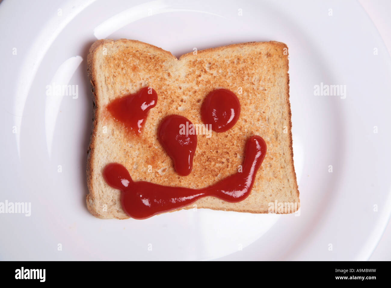 tomato sauce face on childs toast Stock Photo - Alamy