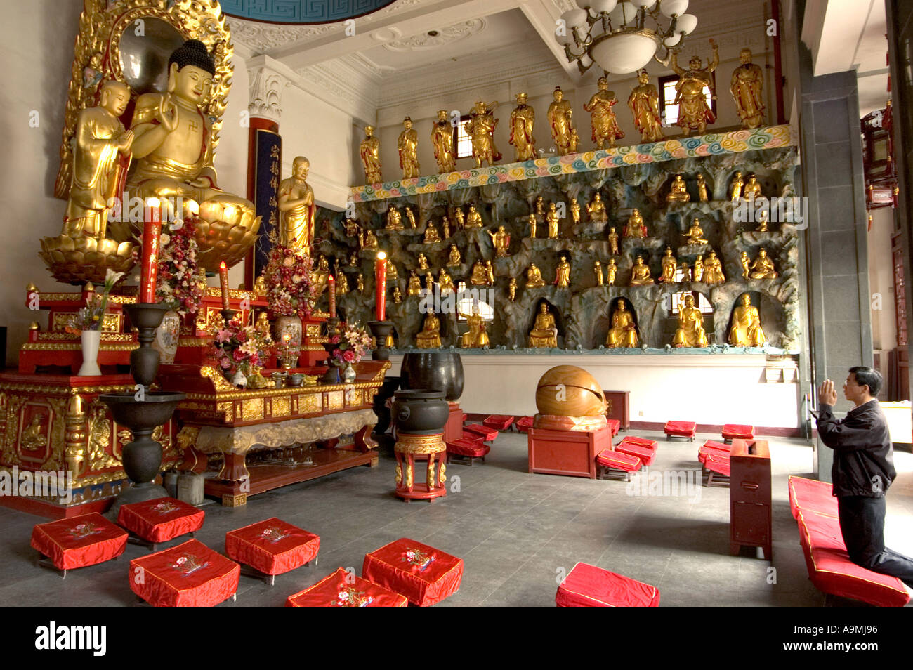 PERSON PAYING HOMAGE TO GOLDEN BUDDHA STATUES IN FAZANGJIANGSI BUDDHIST ...