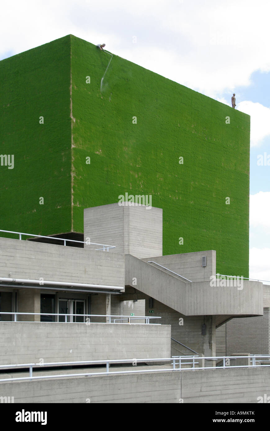 Brutalist architecture concrete wall National Theatre covered by vertical grass man watering ...