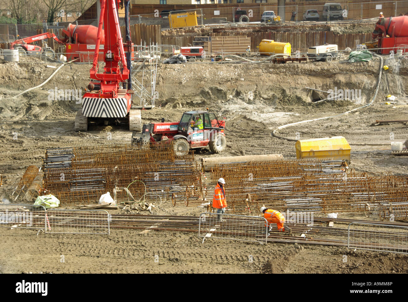 Construction site workmen assemble steel reinforcing cages ready for ...