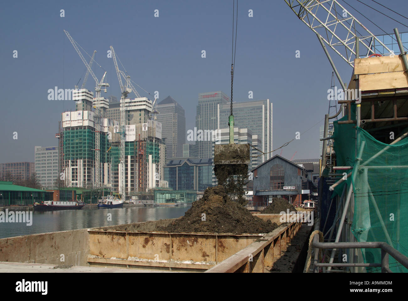Construction building site crane loads barge excavated earth from ...