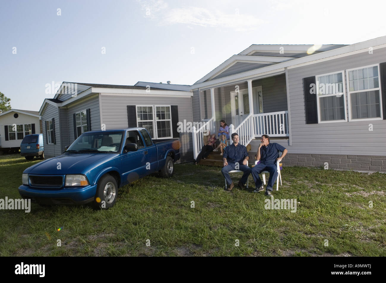 Blue-collar men sitting and talking in front yard of trailer home Stock ...