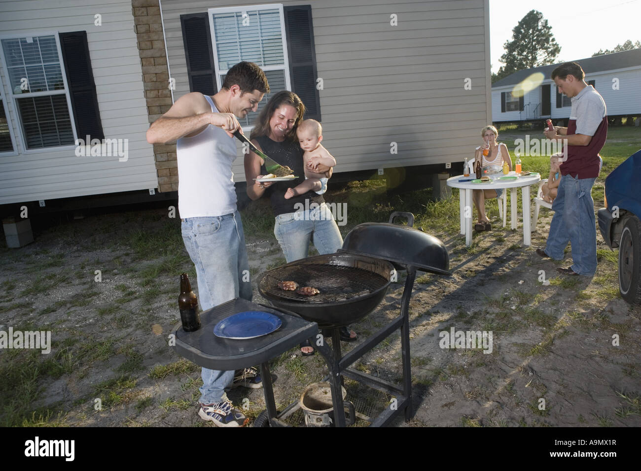 Blue collar families enjoying a cookout in front of trailer home Stock ...