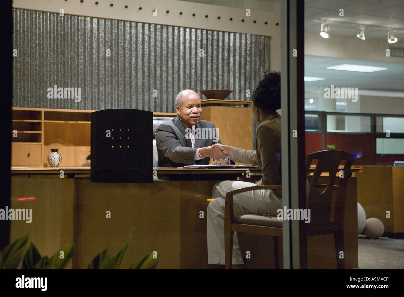 View through window of man and woman talking in an office Stock Photo ...