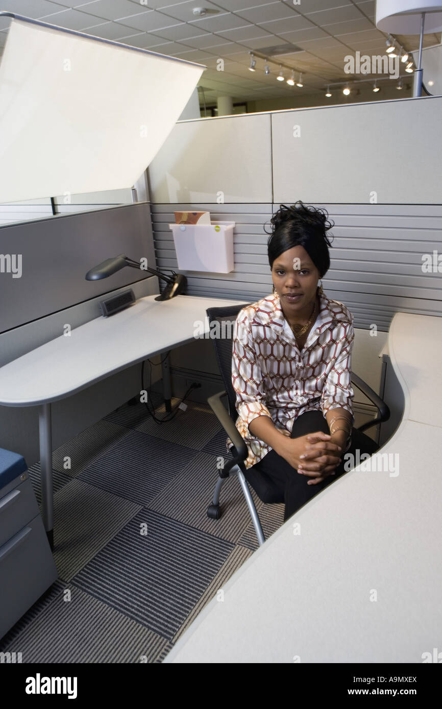 Portrait of a pensive young woman sitting in a new office cubicle Stock ...