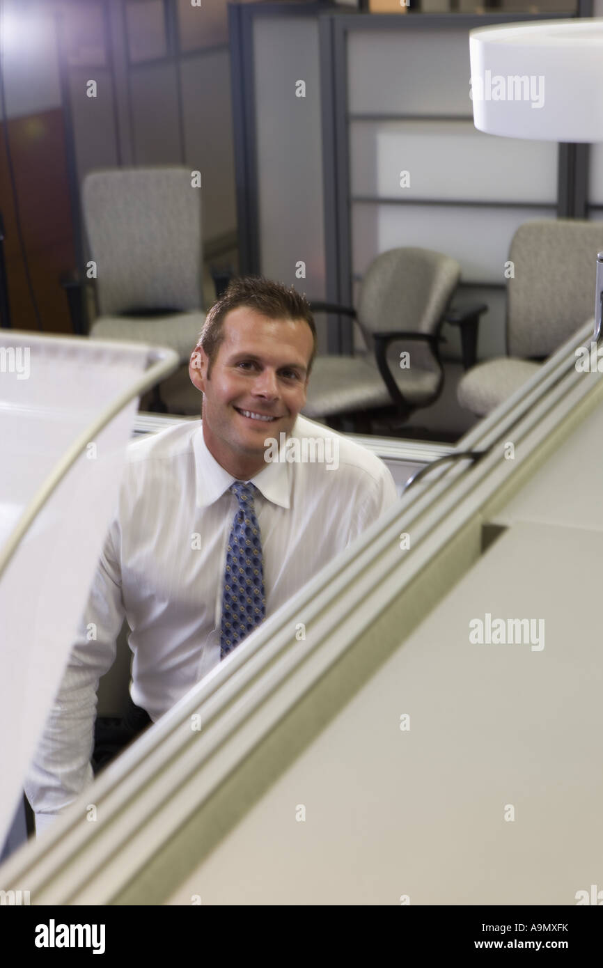 Portrait of a smiling young man looking over his cubicle wall Stock ...