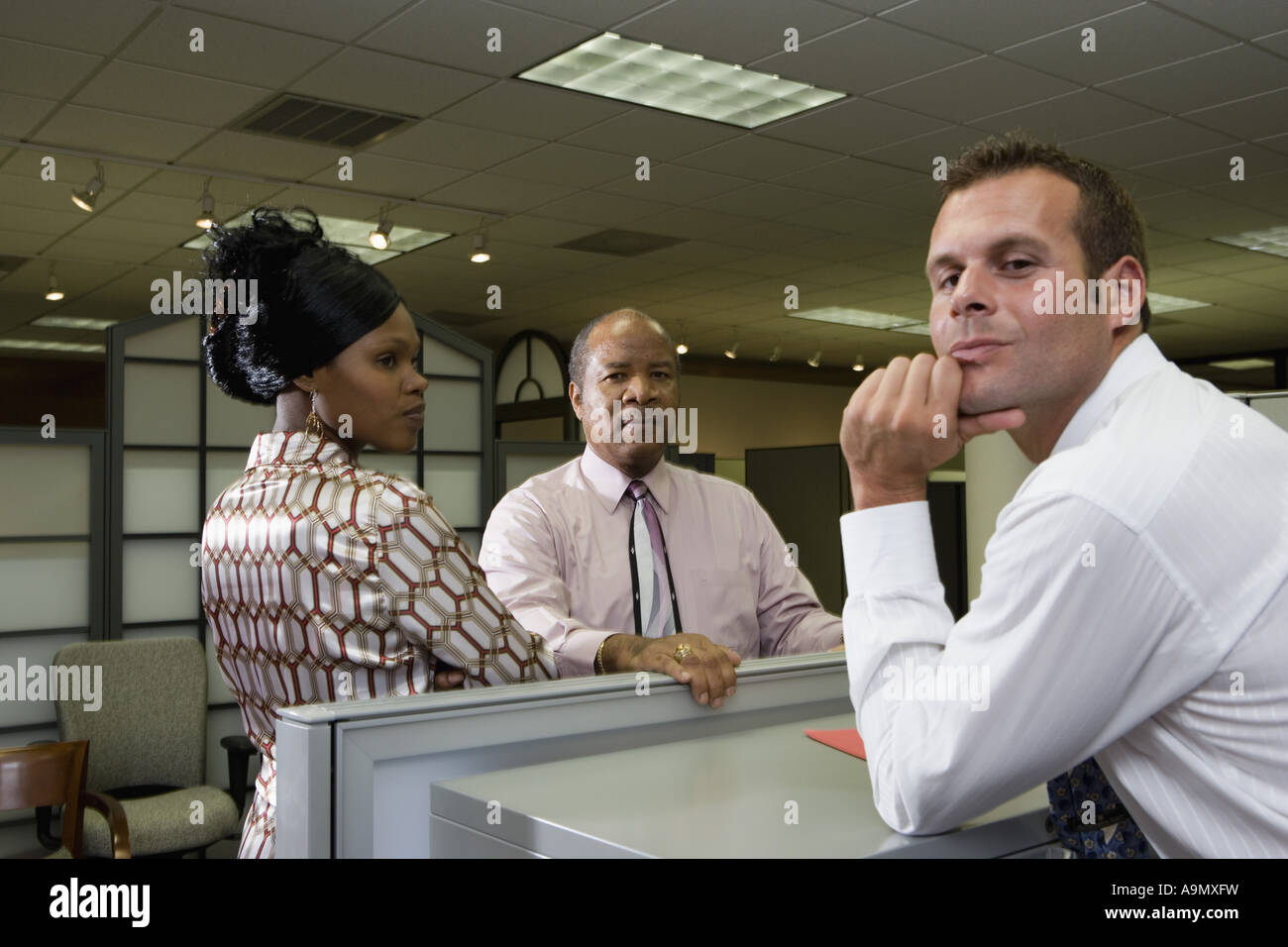 Group of co-workers standing around a cubicle Stock Photo - Alamy