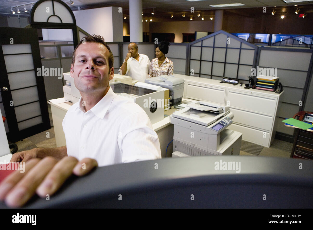 Office worker looking over cubicle wall near office equipment Stock ...