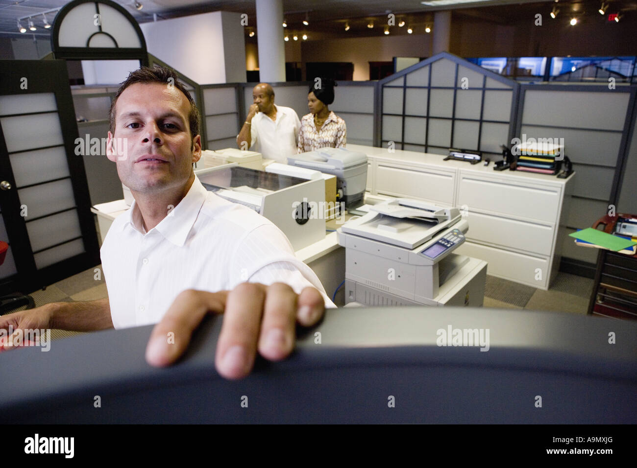 Office worker looking over cubicle wall near office equipment Stock ...