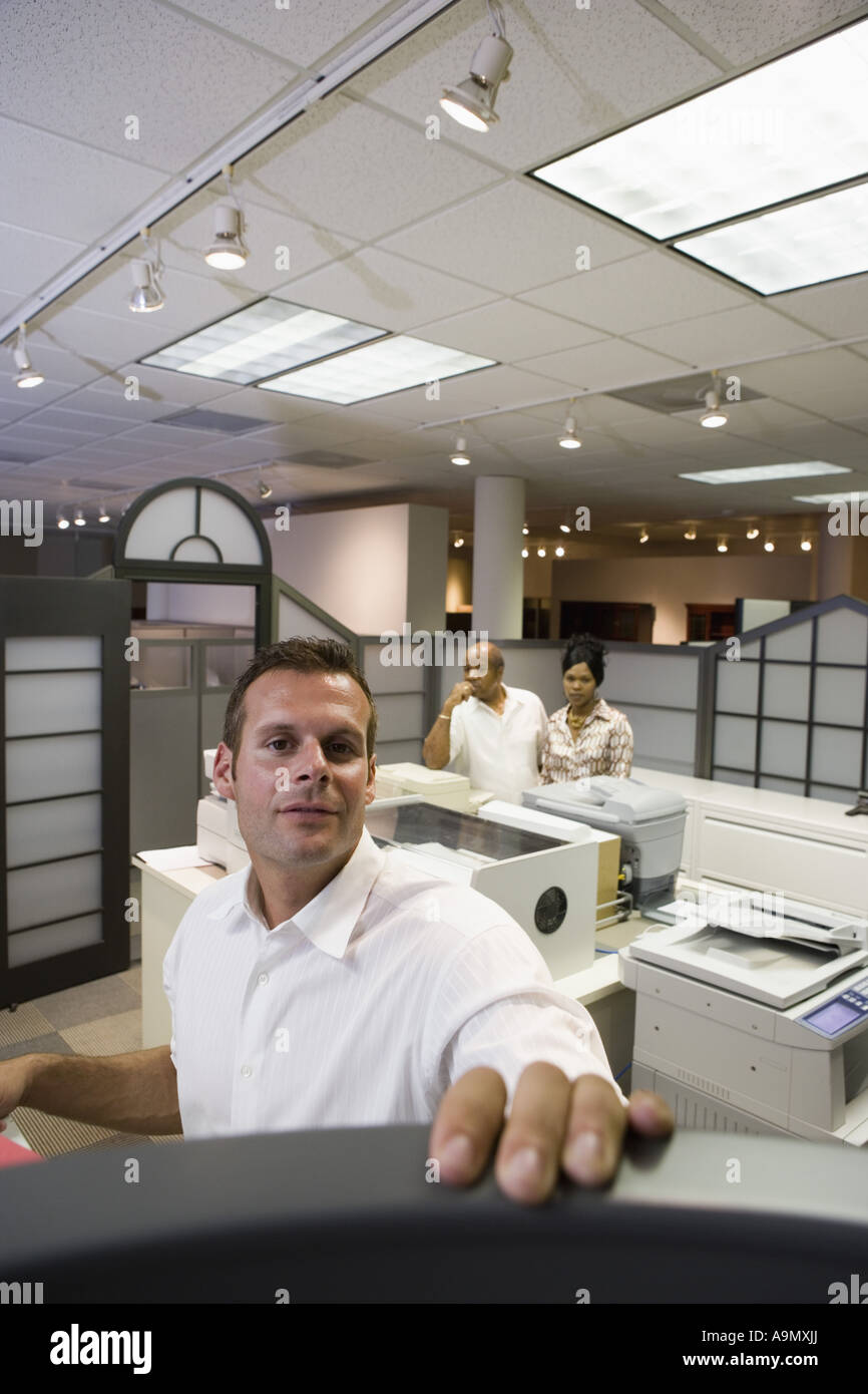 Office worker looking over cubicle wall near office equipment Stock ...