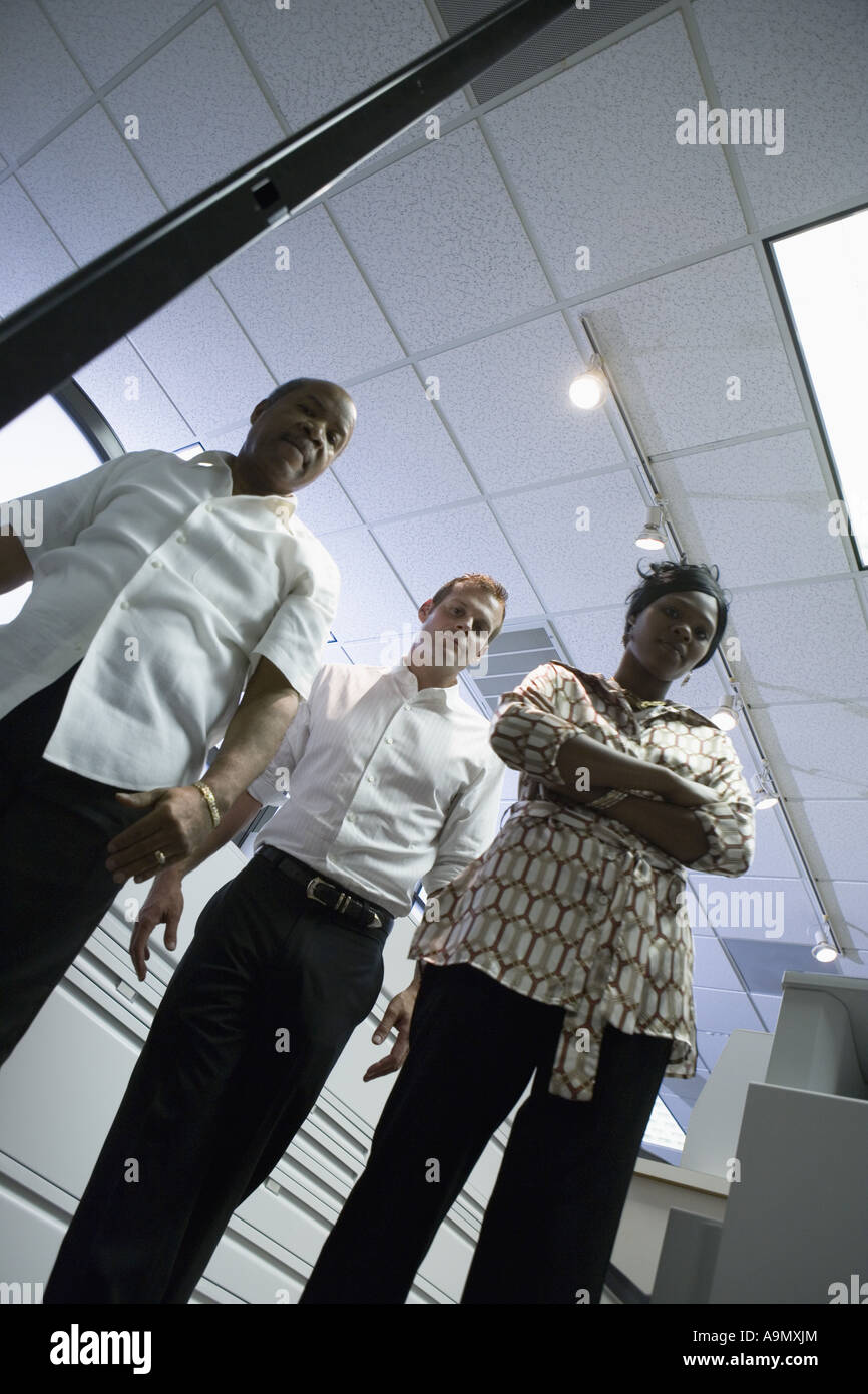 Long angle portrait of three business people in an office Stock Photo ...