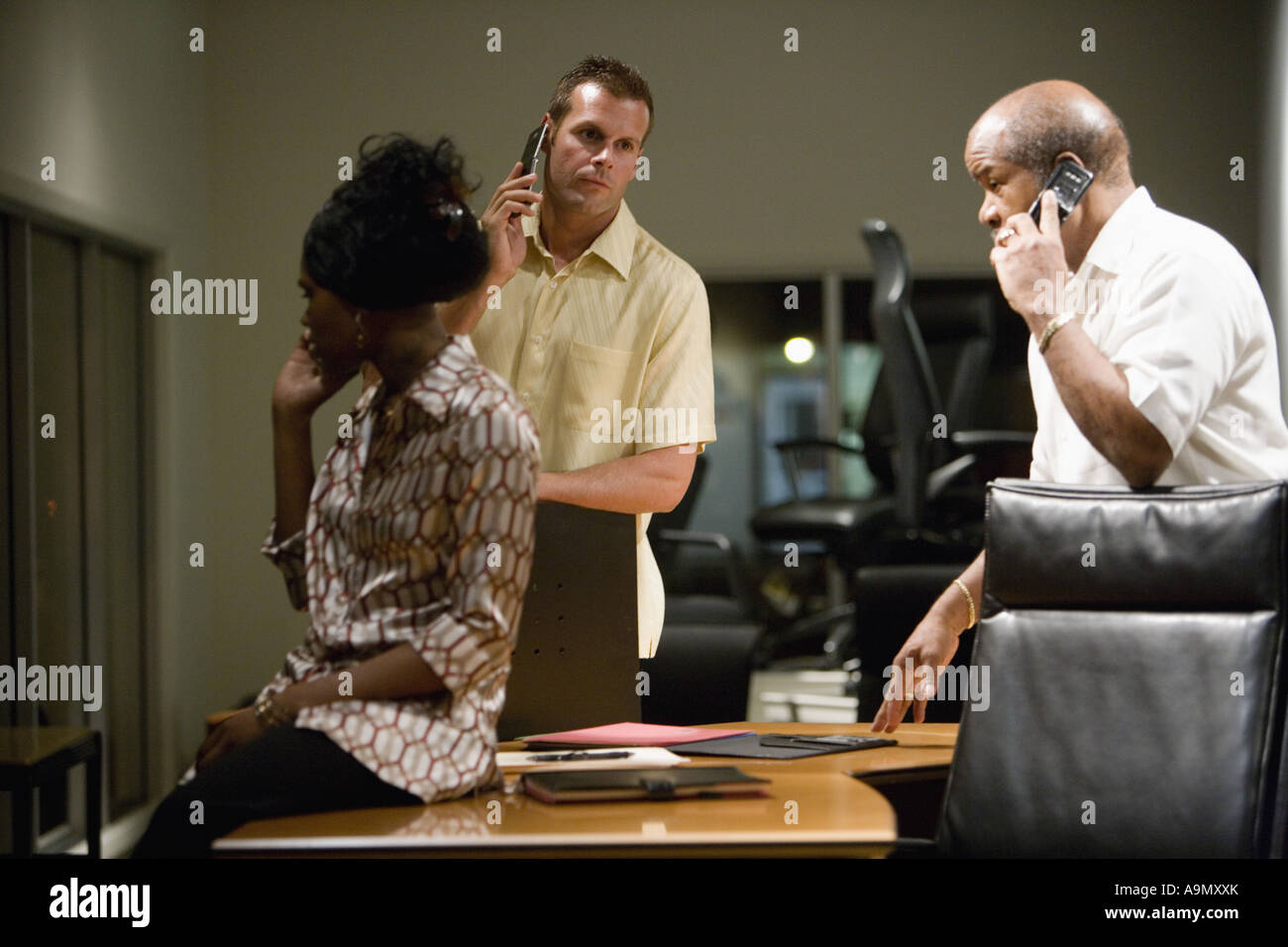 Businesspeople using mobile phones in office Stock Photo - Alamy