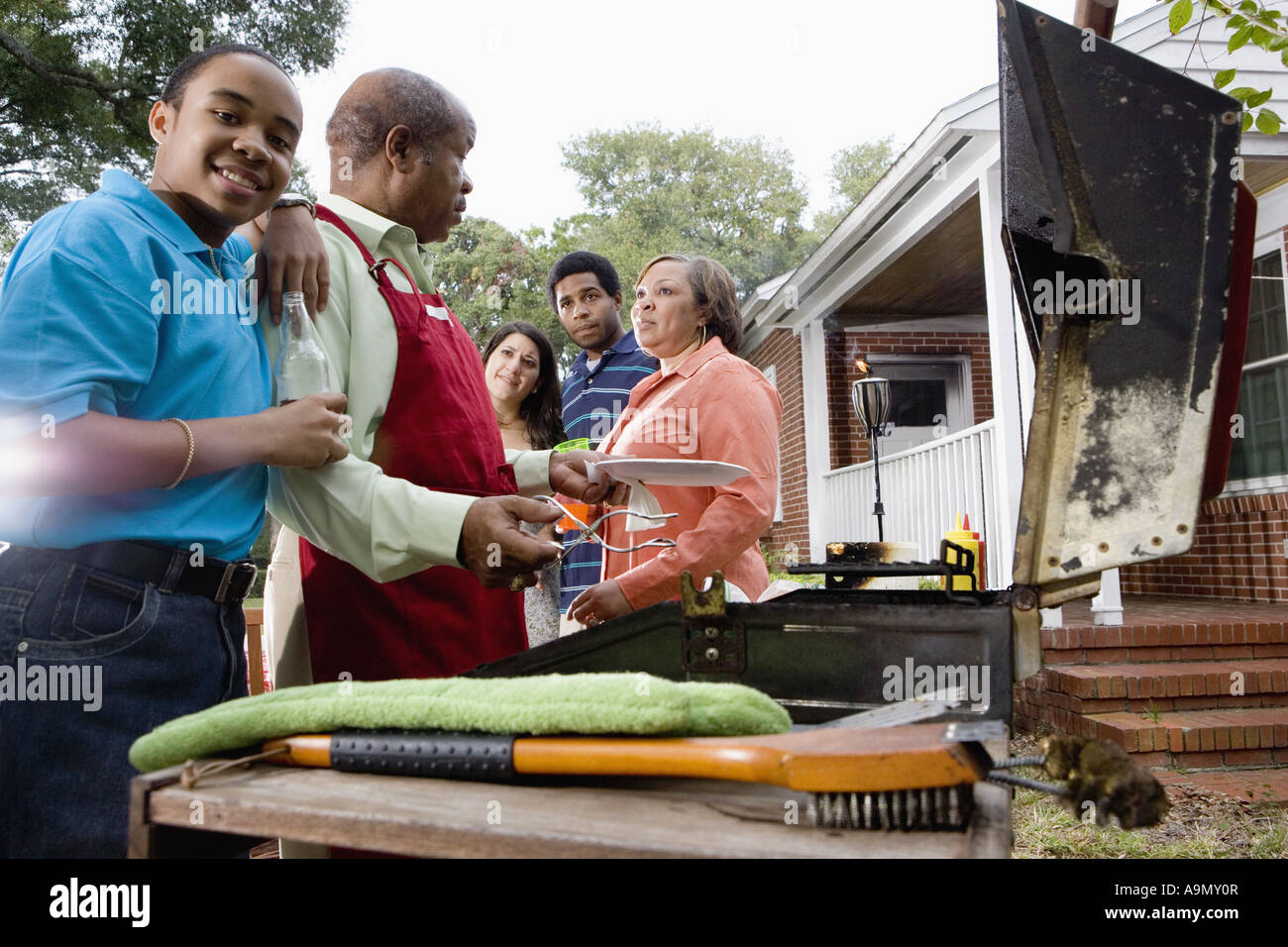 Family and friends enjoying backyard cookout Stock Photo - Alamy