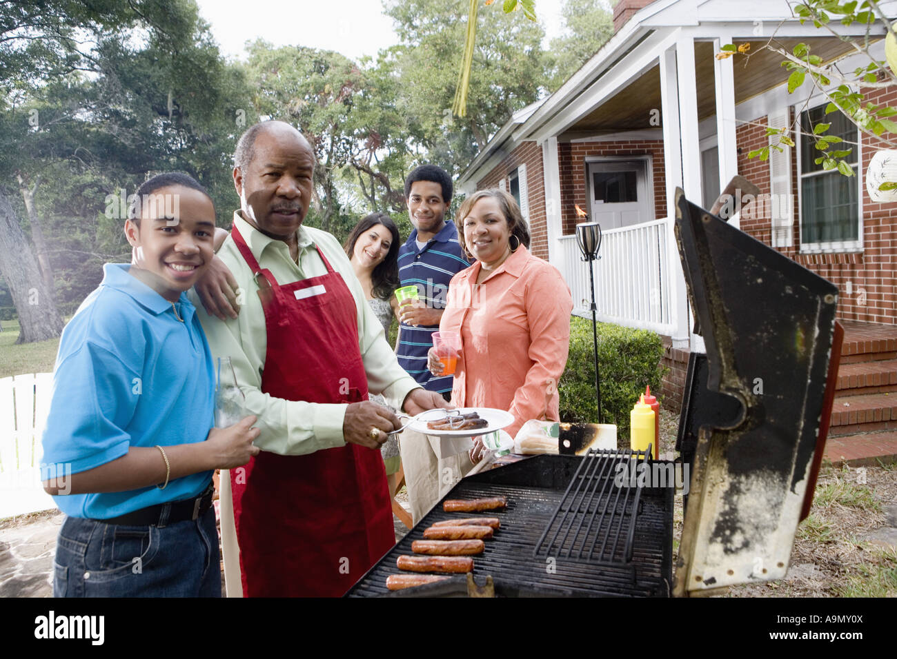 Family and friends enjoying backyard cookout Stock Photo - Alamy