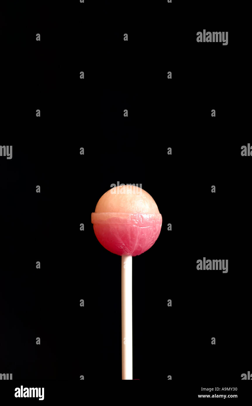 vertical close up of red lollipop against black background Stock Photo ...