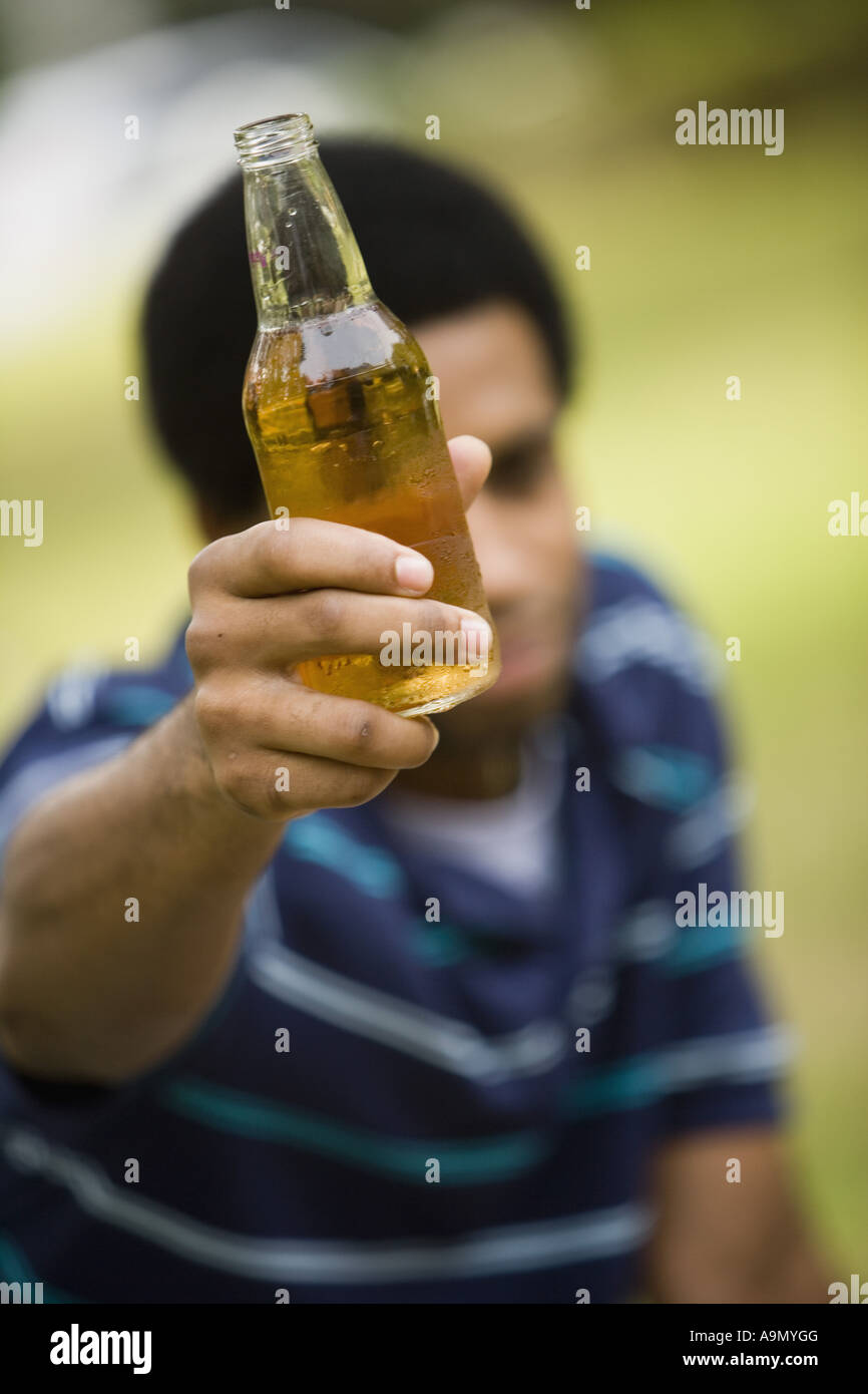 A young man holding up a drink bottle Stock Photo - Alamy