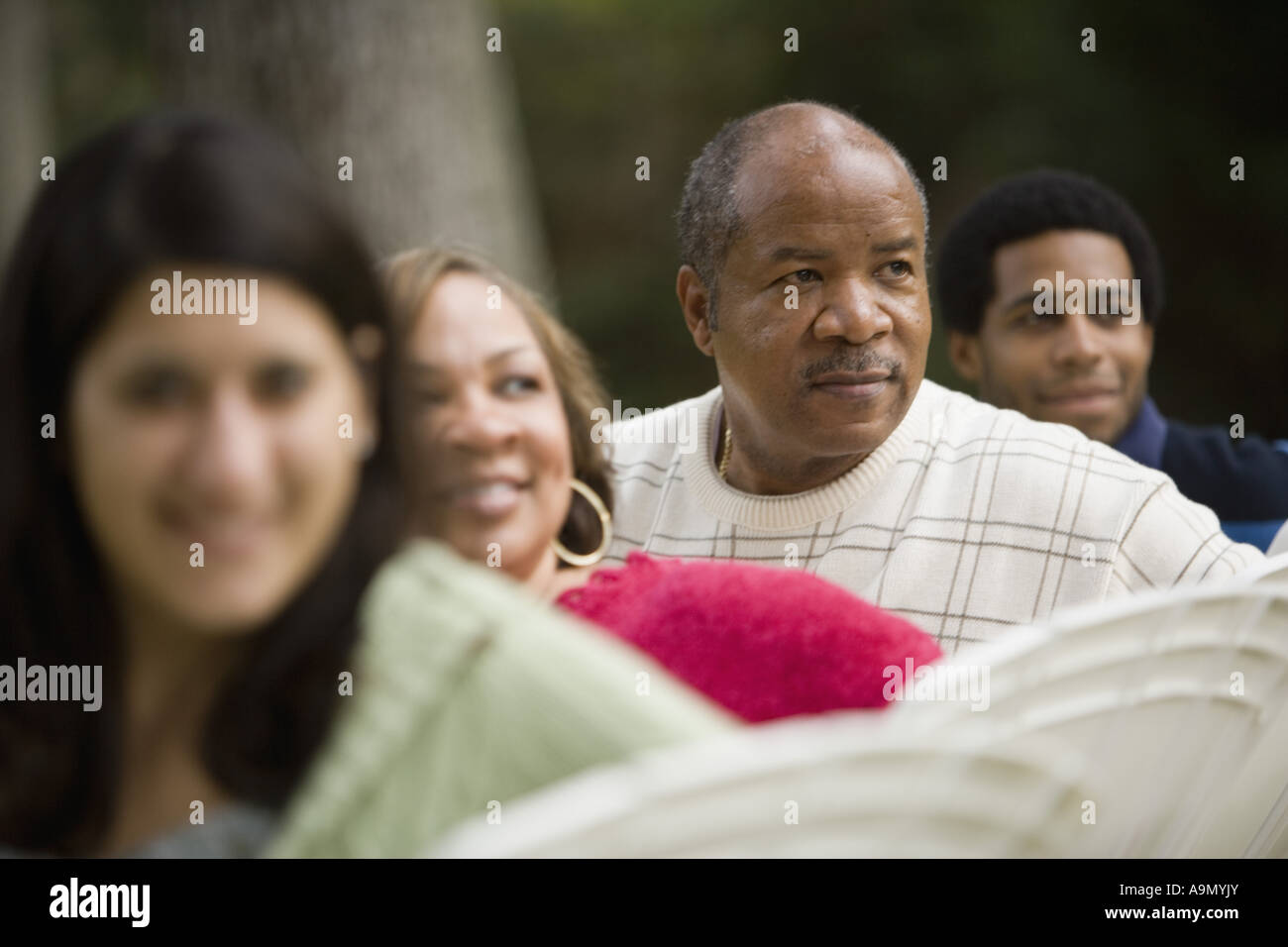 A family sitting on lawn chairs looking behind them Stock Photo - Alamy