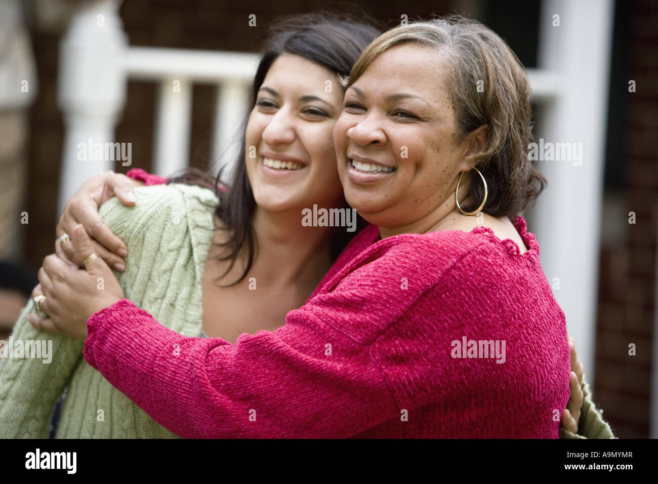 Mature woman embracing younger woman Stock Photo - Alamy