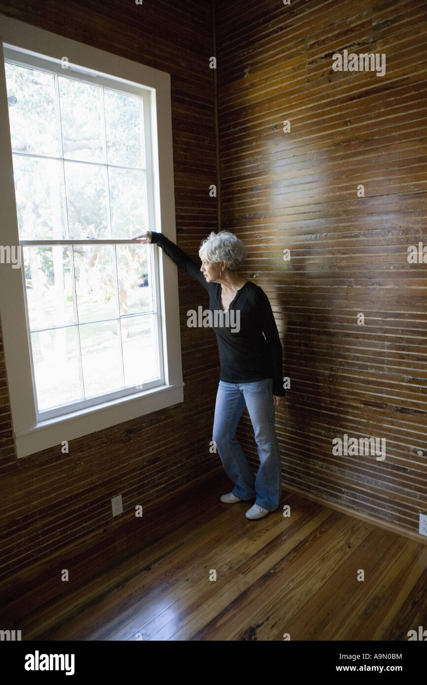 Mature woman gazing out window Stock Photo - Alamy